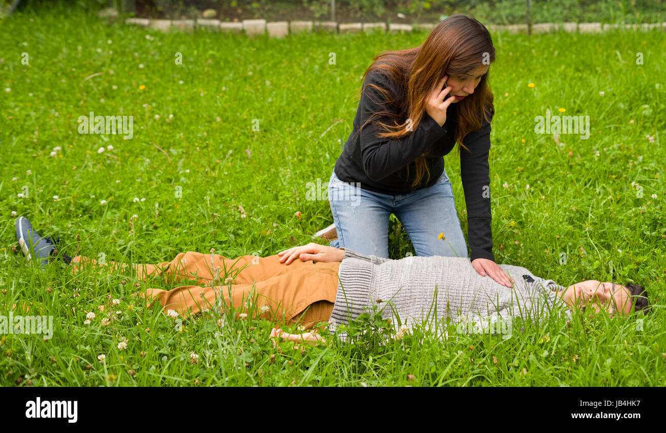 Beautiful woman giving first aid to a handsome young man and using her ...