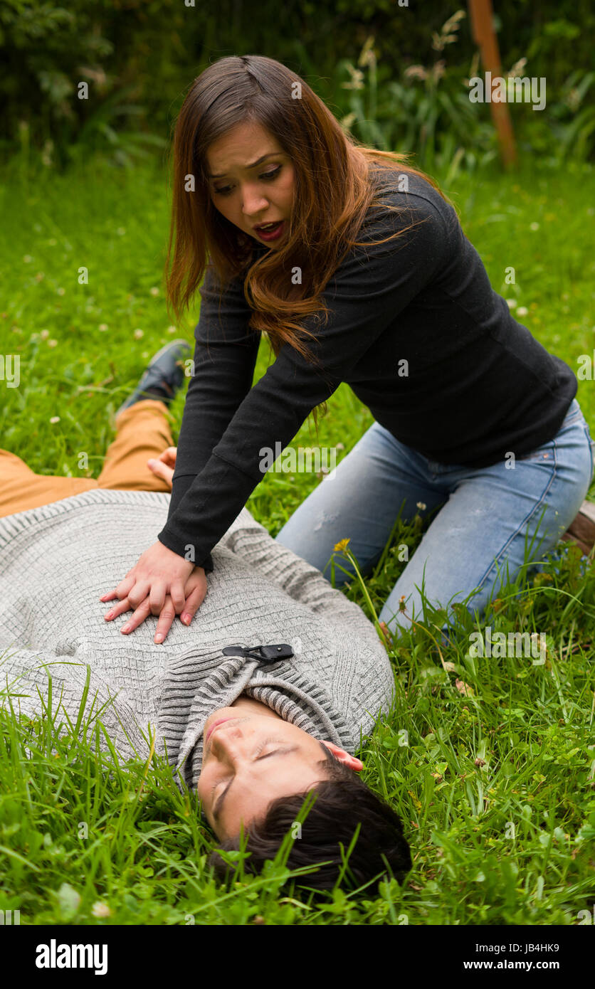 Beautiful woman giving first aid to a handsome young man ...