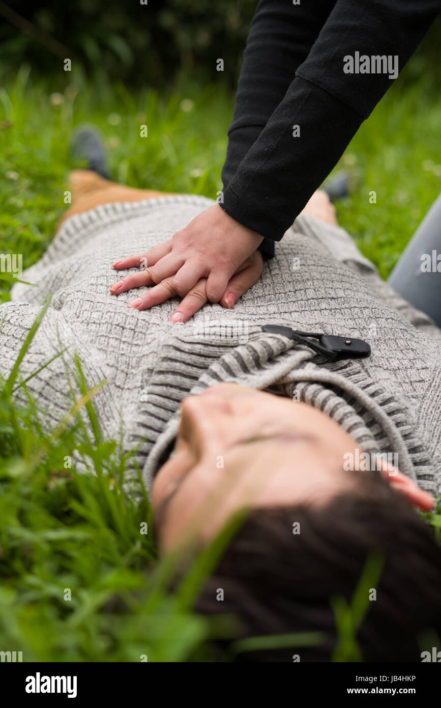 Close up of a beautiful woman giving first aid to a handsome young man ...