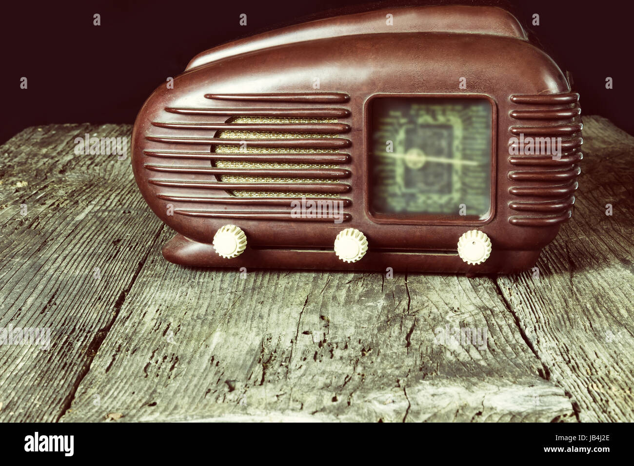 Vintage photo of old radio standing on the old wooden desk. Released in ...