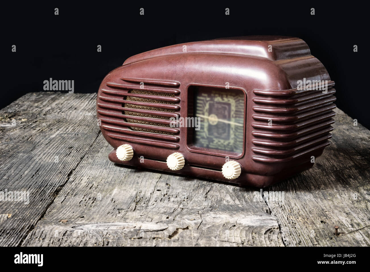 Side view of old radio standing on the old wooden desk. Edited as a ...