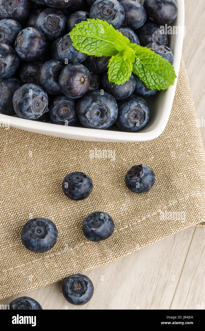 Fresh healthy blueberries in small bowl on wood table Stock Photo - Alamy