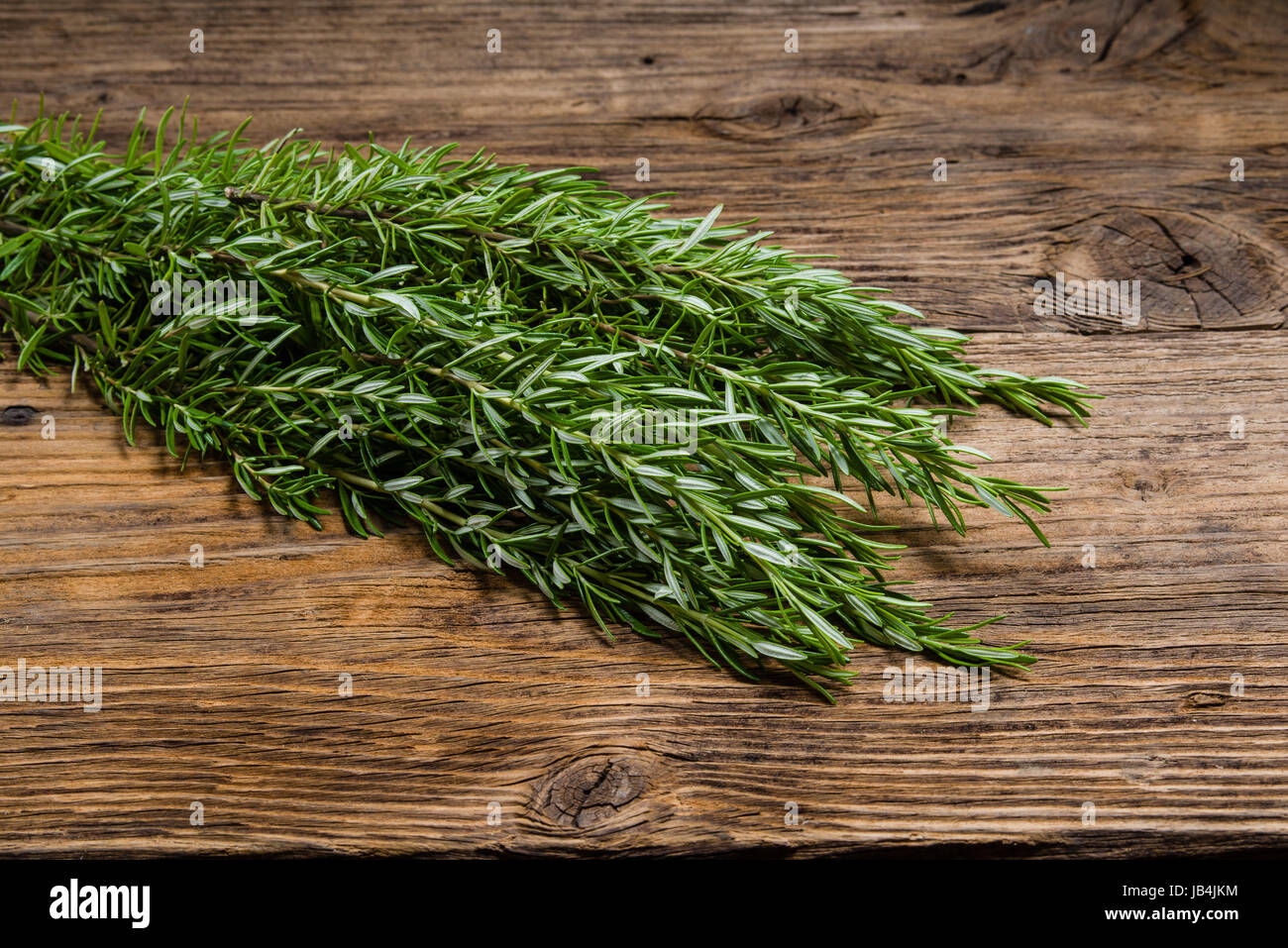 Freshly picked bundle of rosemary on a wooden table Stock Photo - Alamy