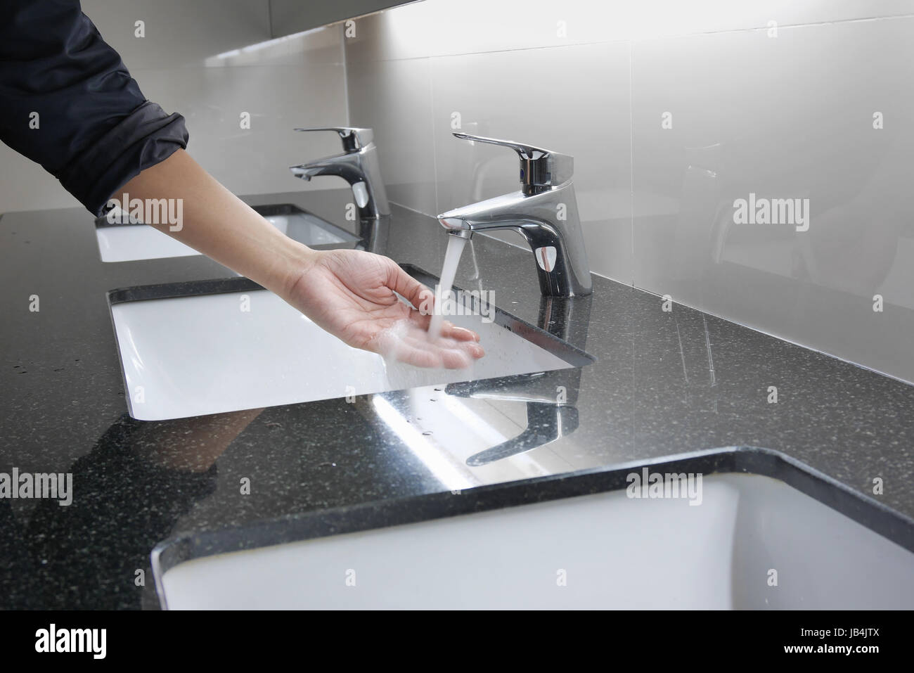 white washbasin and faucet on granite counter with hand washing Stock ...