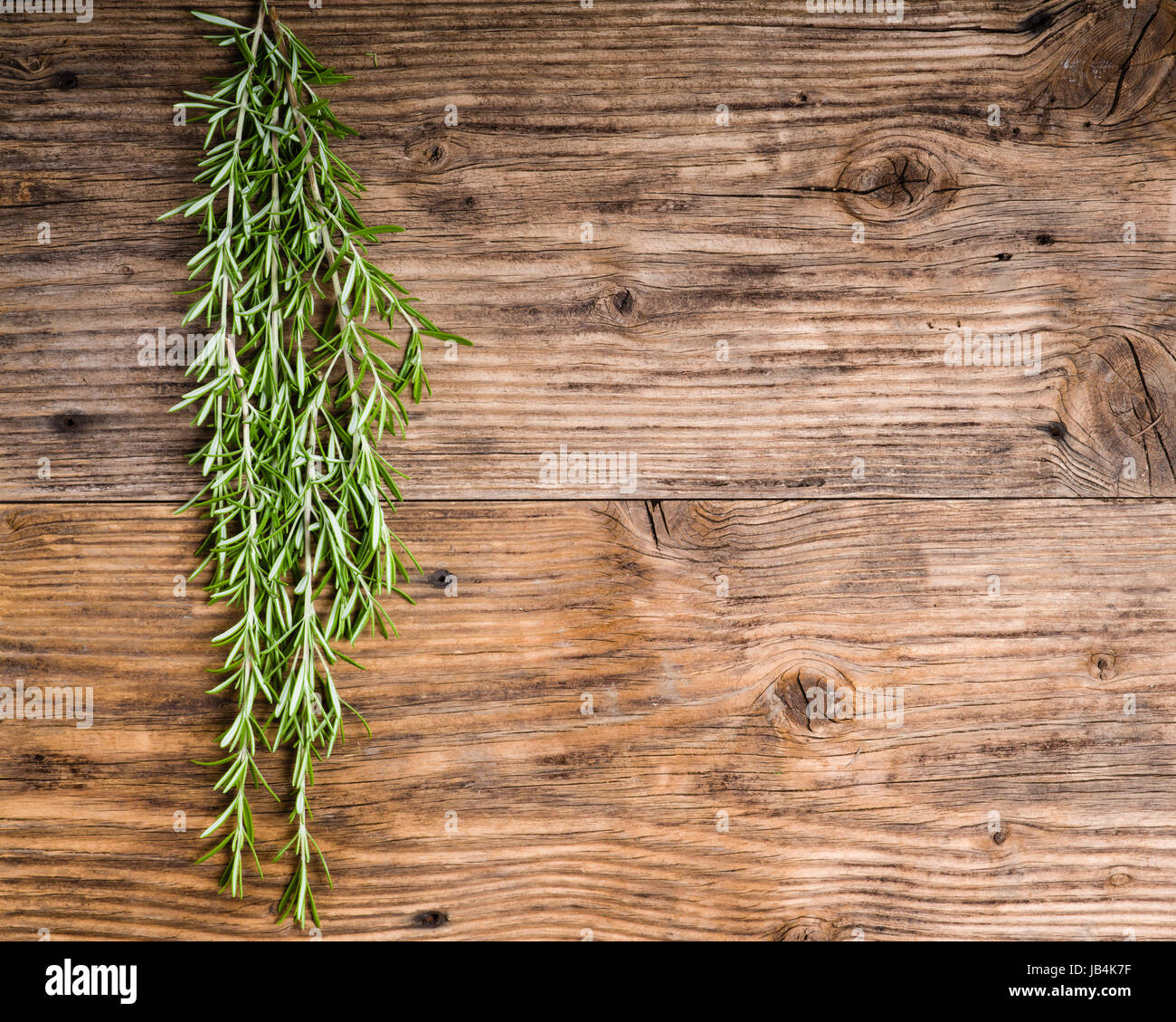 Freshly picked sprig of rosemary on a wooden table Stock Photo - Alamy