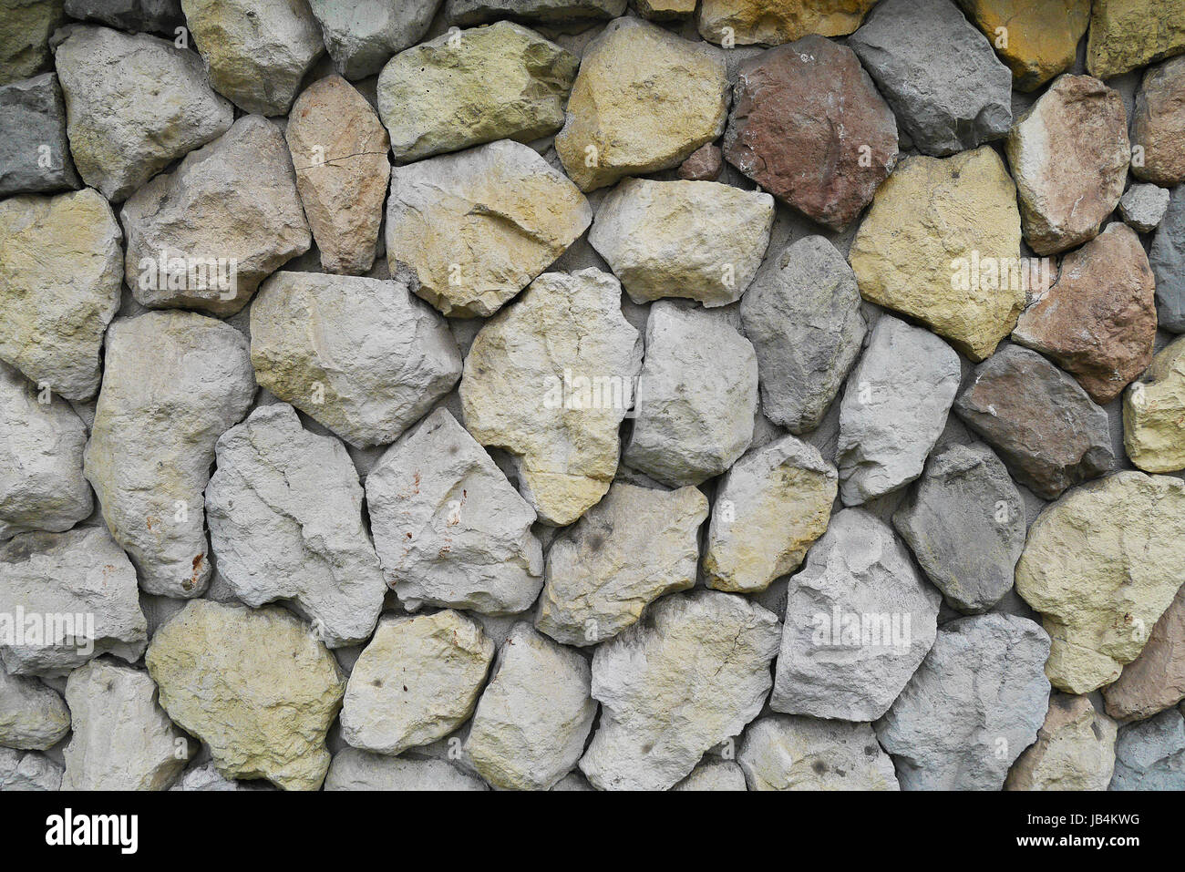 yellow, red, blue, stones and pebbles on gray wall, background, closeup ...