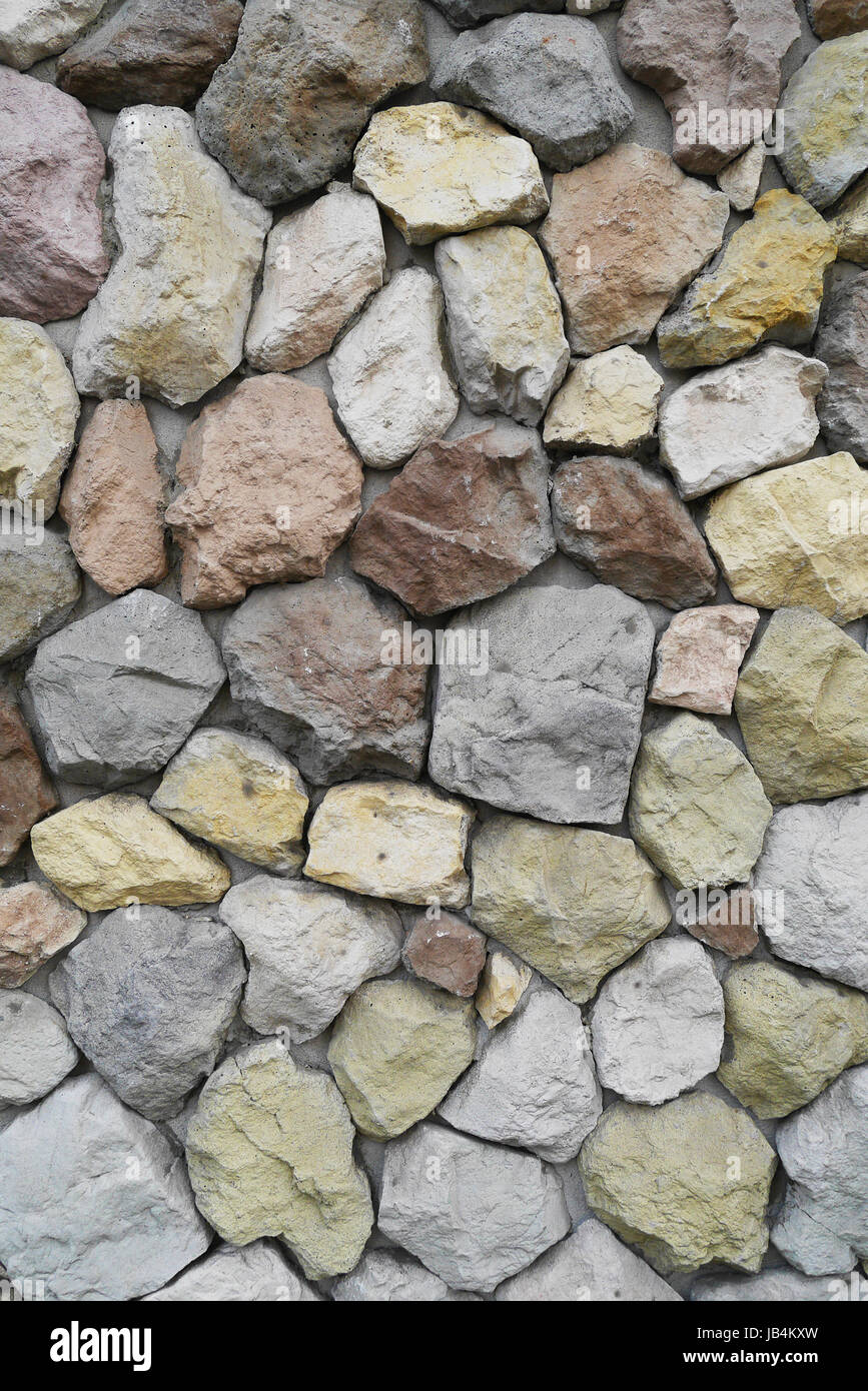 yellow, red, blue, stones and pebbles on gray wall, background, closeup ...