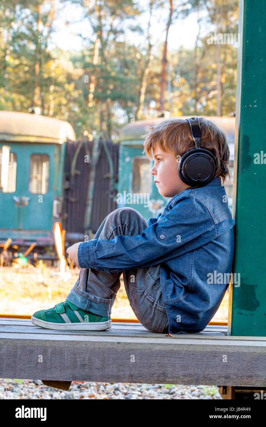 little boy with big headphone waiting on a train Stock Photo - Alamy