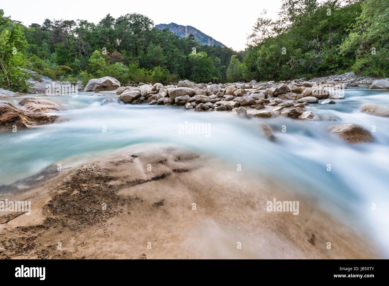 Long exposure of the water flowing rapidly trough the river, around ...