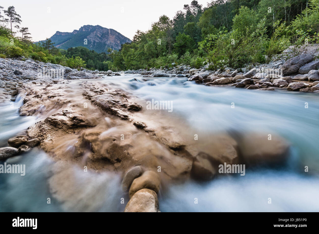 Long exposure of the water flowing rapidly trough the river, around ...