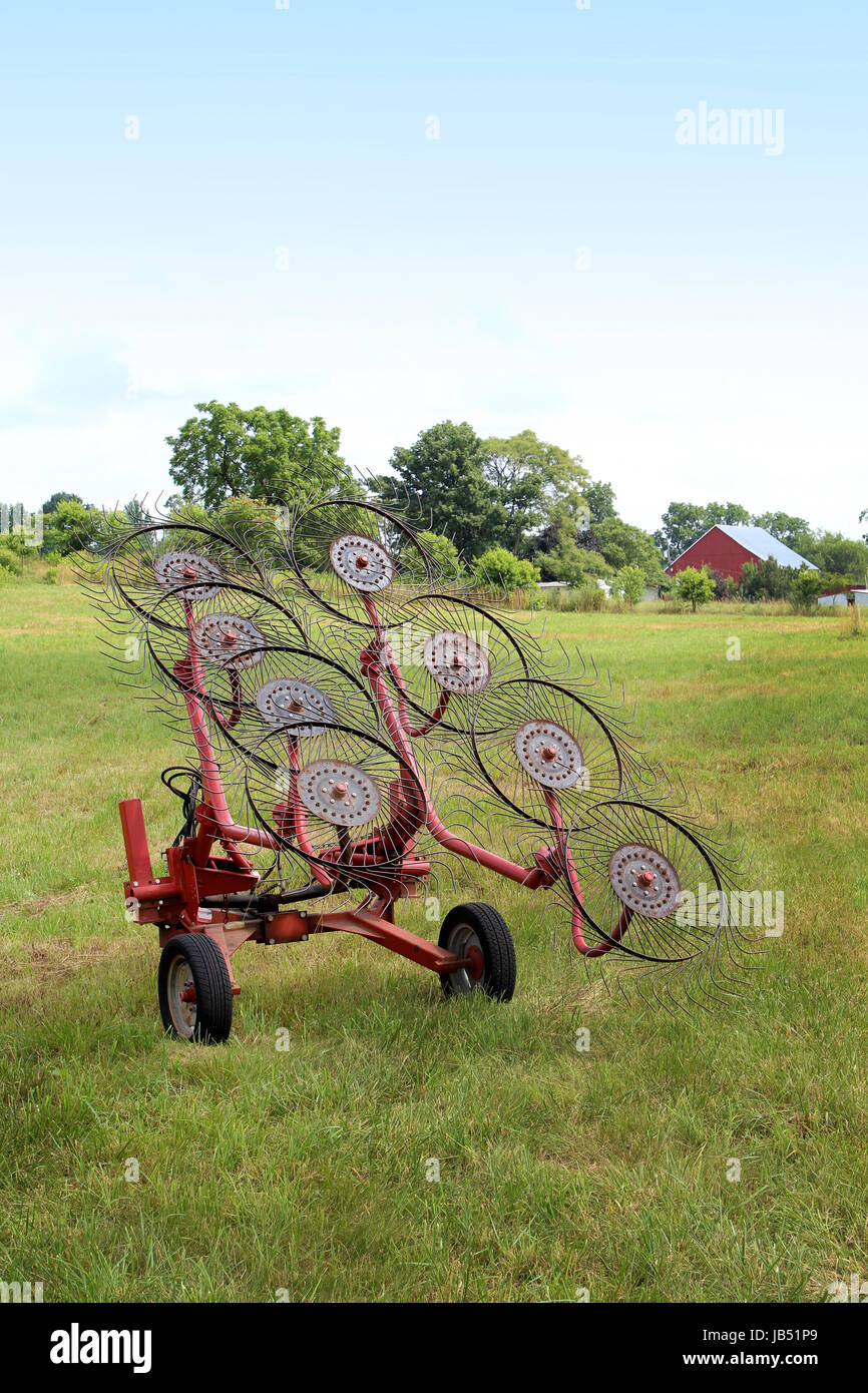 A hay rake sitting in an empty farm field Stock Photo - Alamy