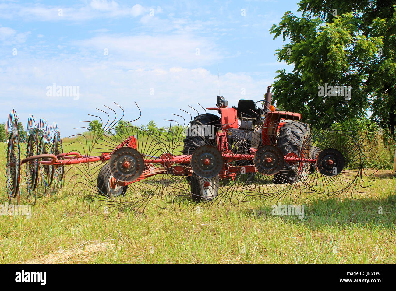 A farm tractor pulling a hay rake in field Stock Photo - Alamy