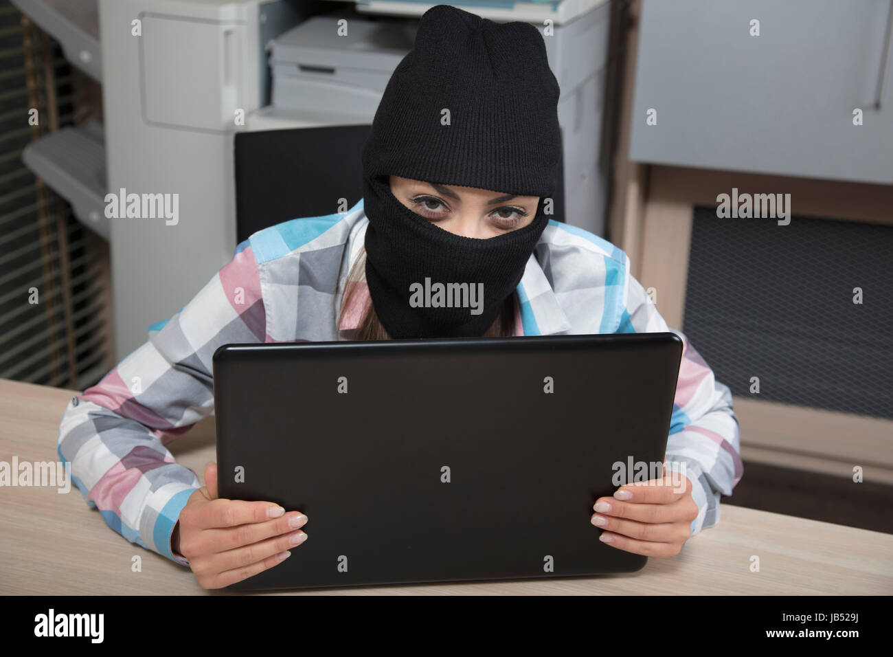 Hacker looks from behind a computer, looking at you Stock Photo - Alamy