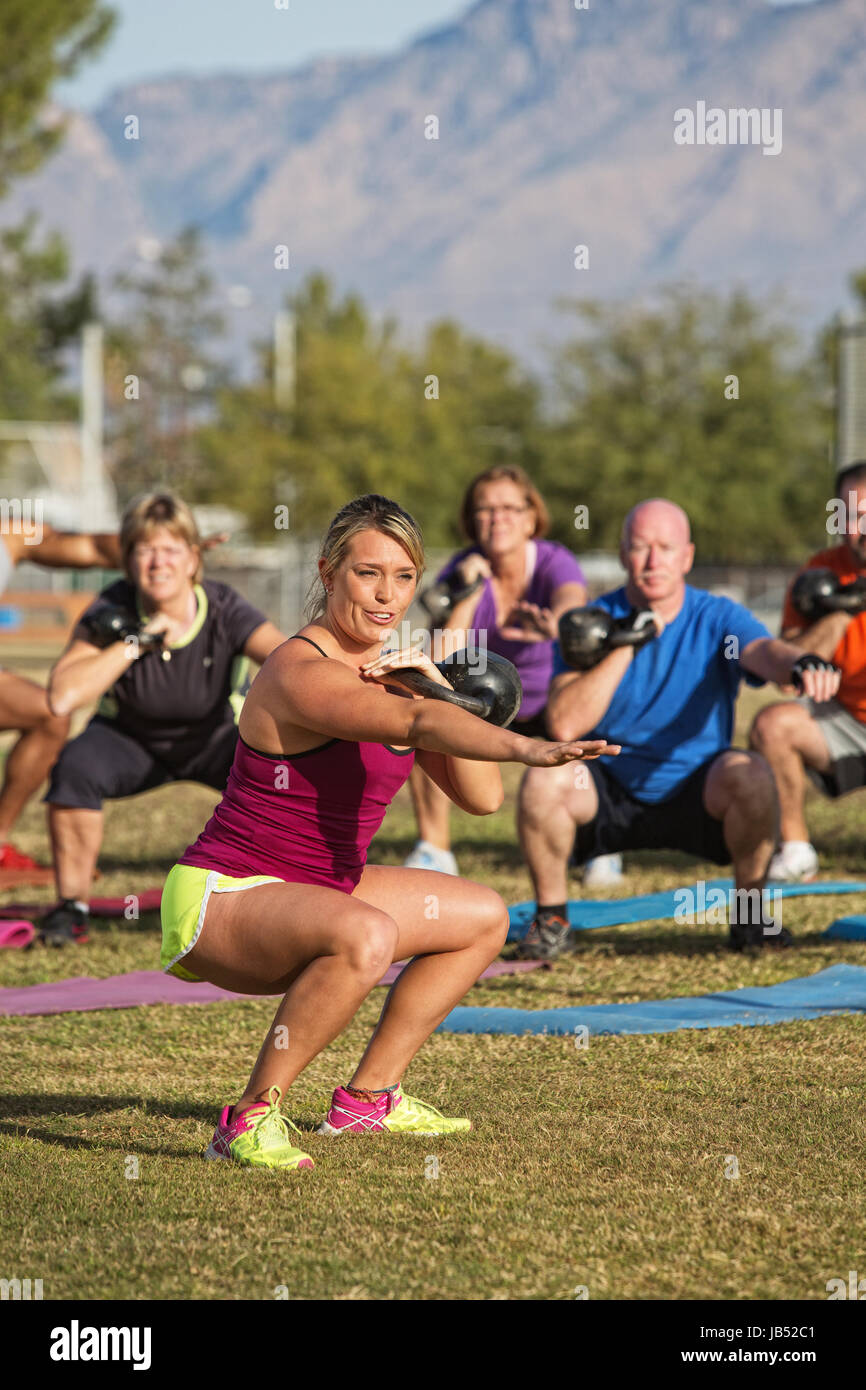 Cheerful fitness instructor leading group of adults Stock Photo - Alamy