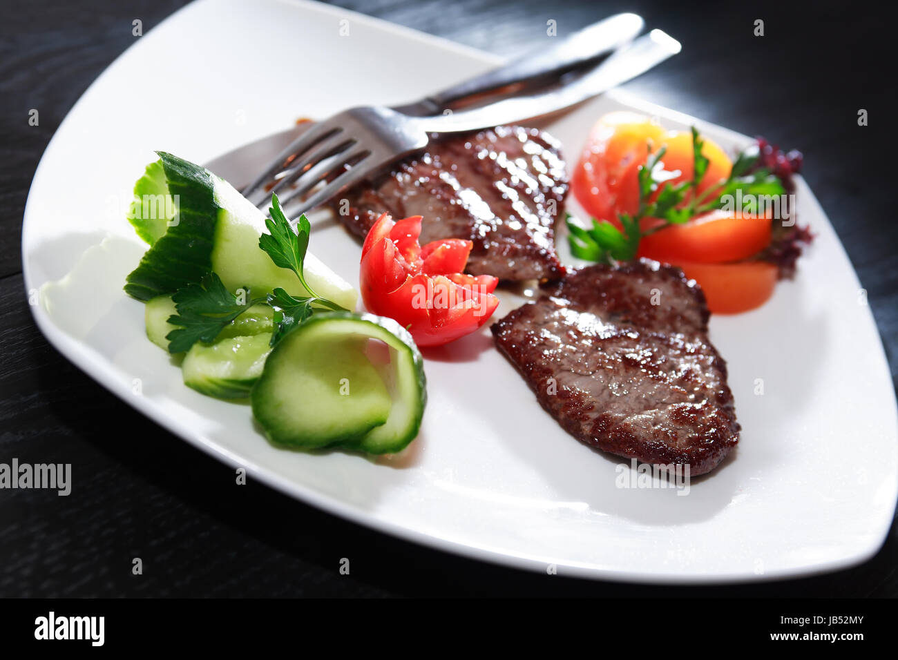 Plate with grilled meat and vegetables on dark wooden table Stock Photo ...