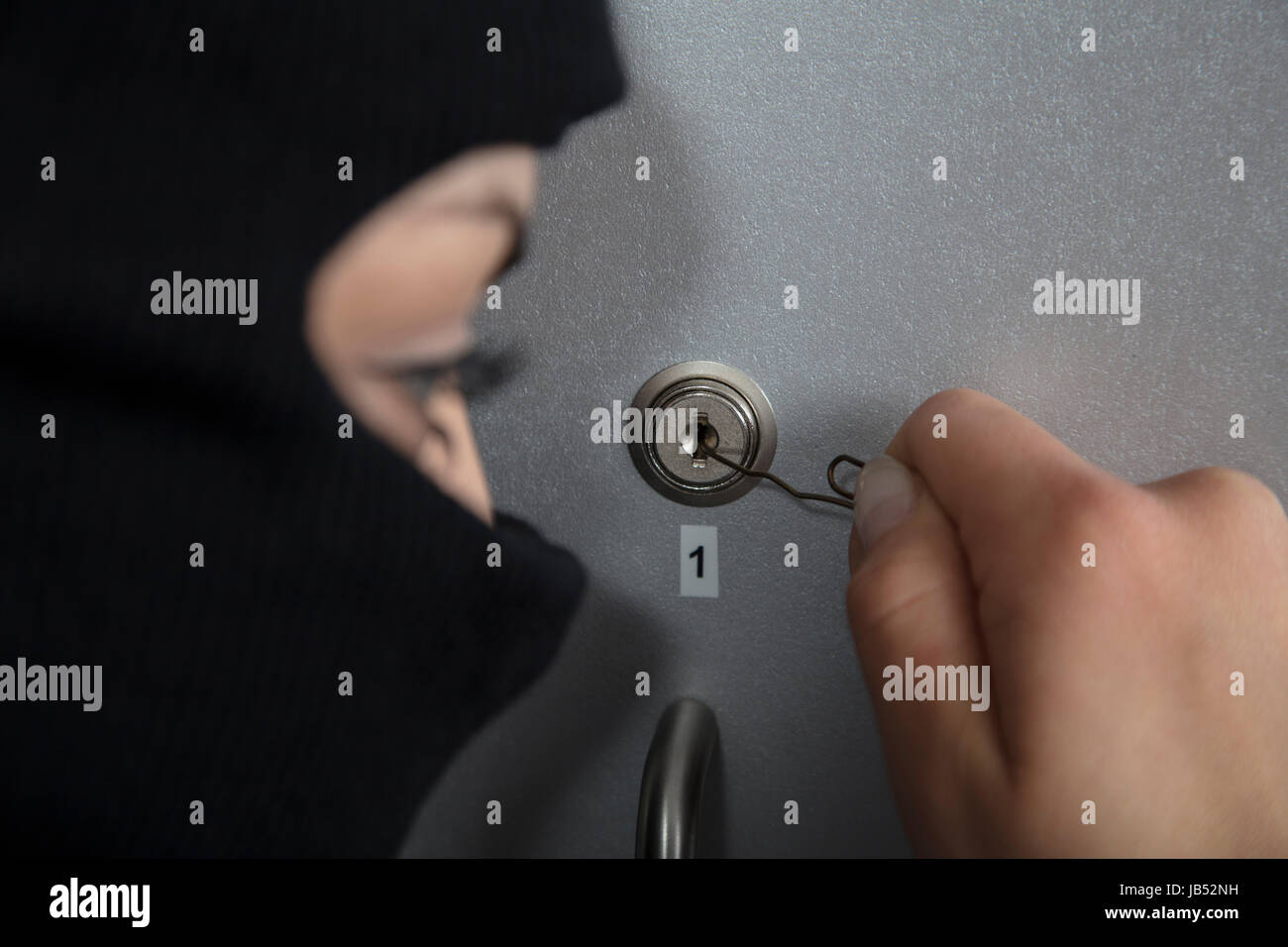 Burglar in action, trying to open the lock Stock Photo - Alamy