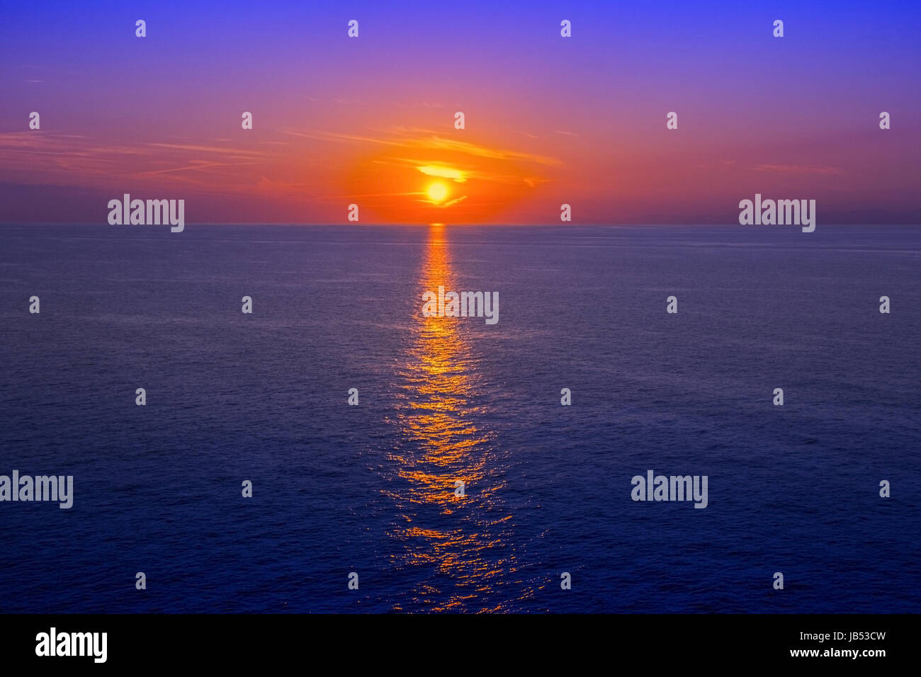 Sunset over sea with reflection in water as background Stock Photo - Alamy