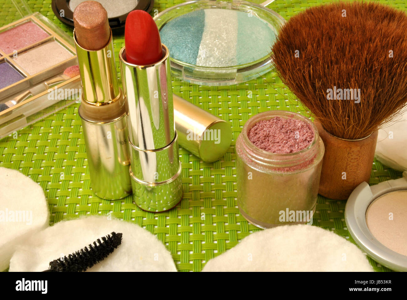 Various types of cosmetics, lipstick, face powder, eye shadow, a mirror ...