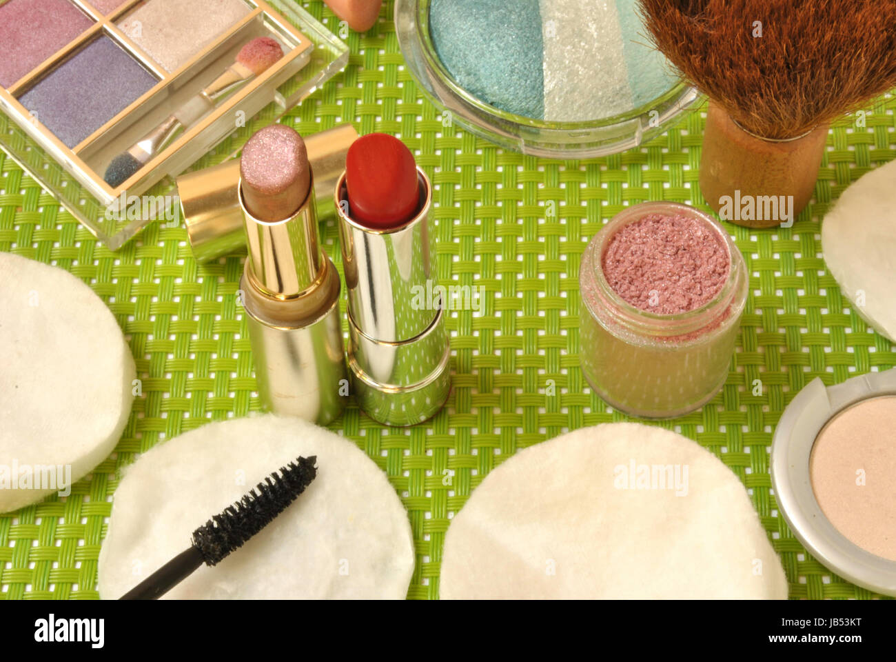 Various types of cosmetics, lipstick, face powder, eye shadow, a mirror ...