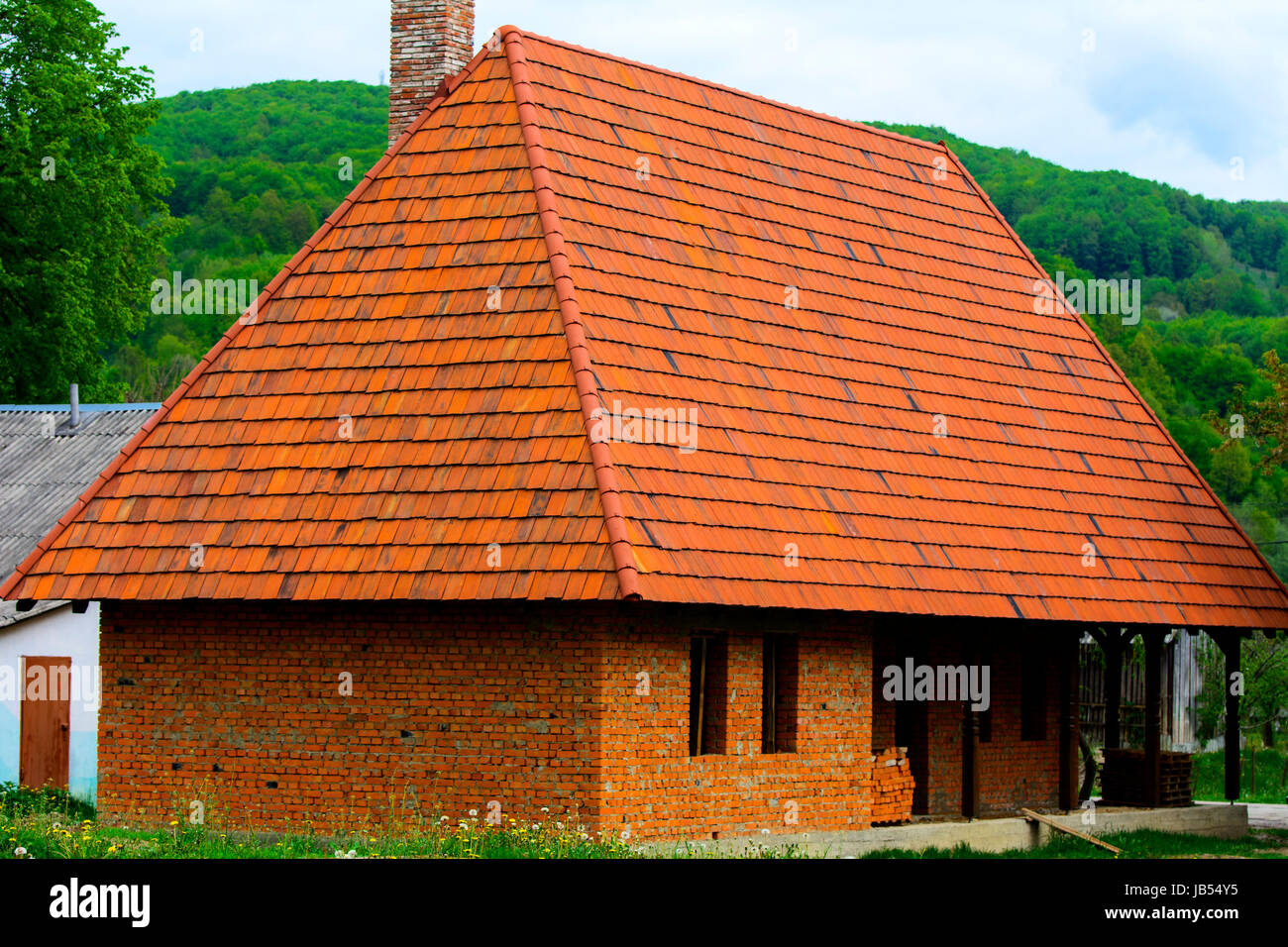 Unfinished house with a tiled roof in the village Stock Photo - Alamy