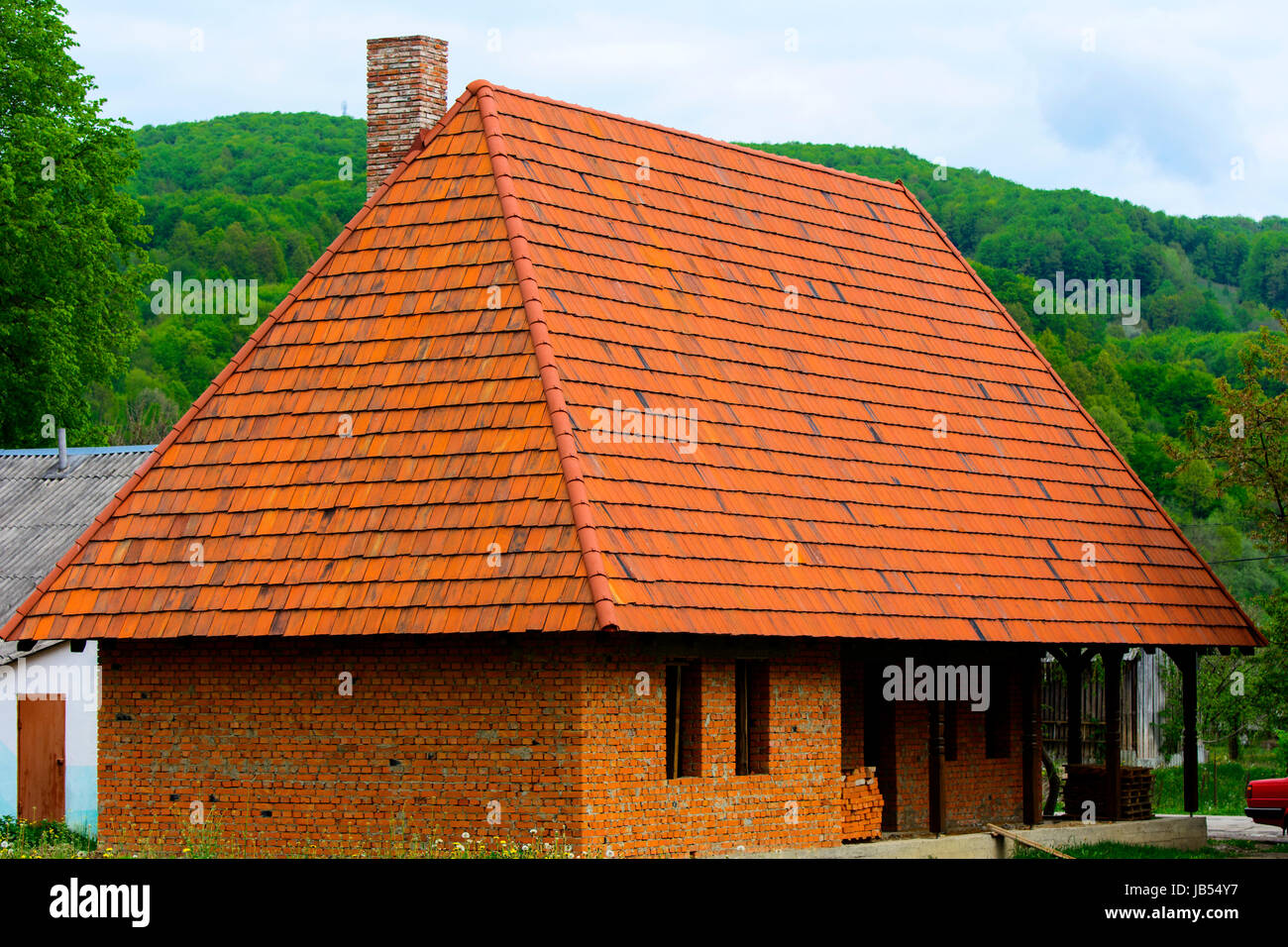 Unfinished house with a tiled roof in the village Stock Photo - Alamy