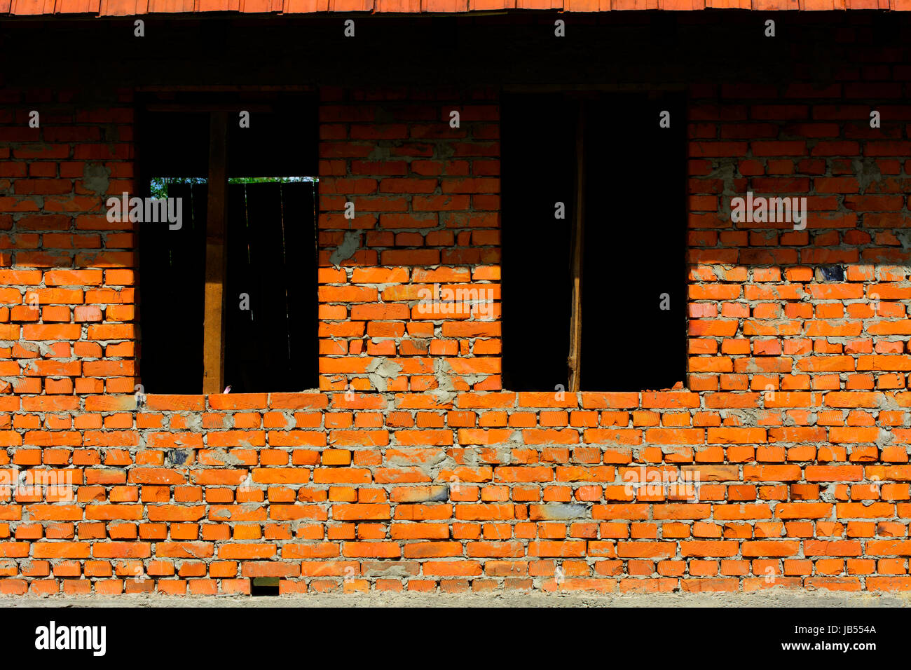 Unfinished house with a tiled roof in the village Stock Photo - Alamy