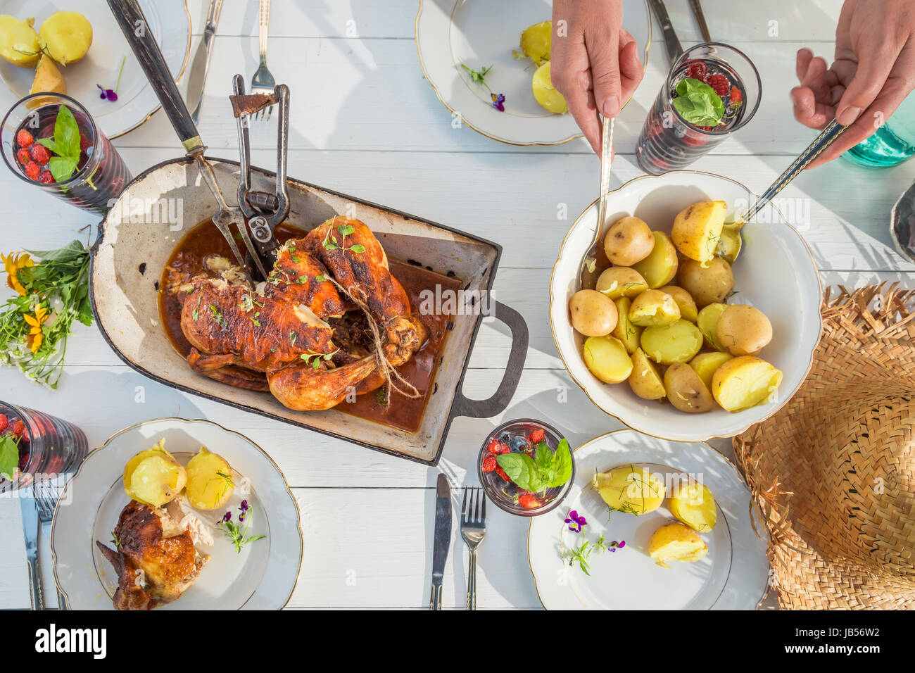 Family dinner with chicken and potatoes on white table Stock Photo - Alamy