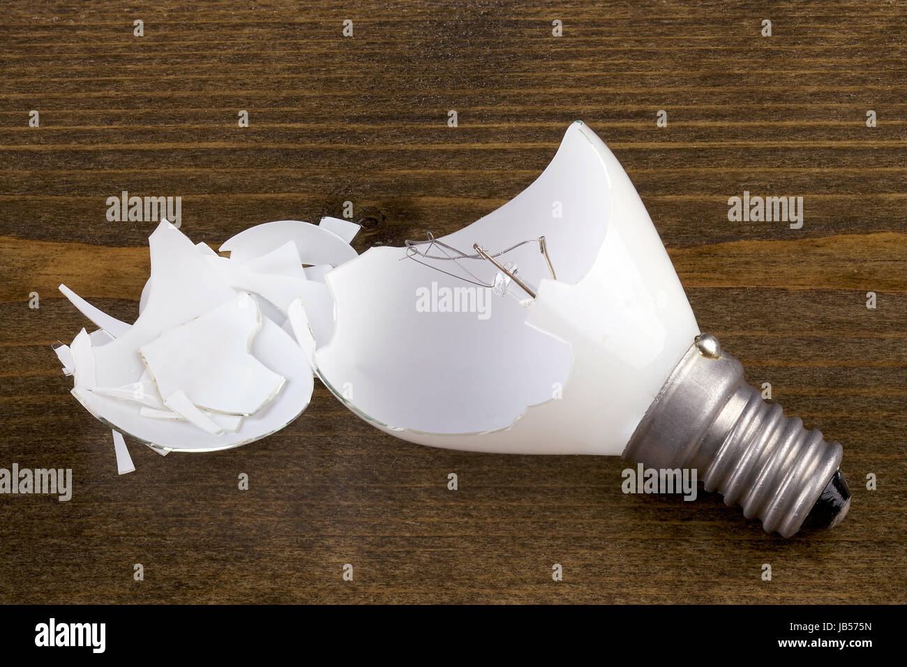 Broken incandescent light bulb on a wooden table Stock Photo - Alamy