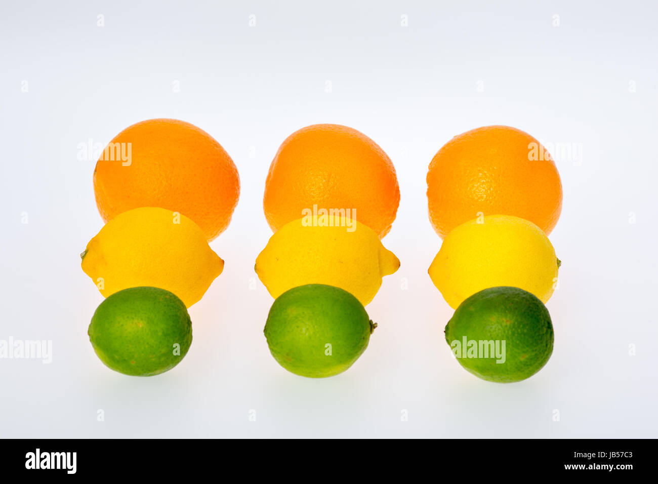 3 oranges, 3 lemons and 3 lime fruits aligned in 3 rows on white ...