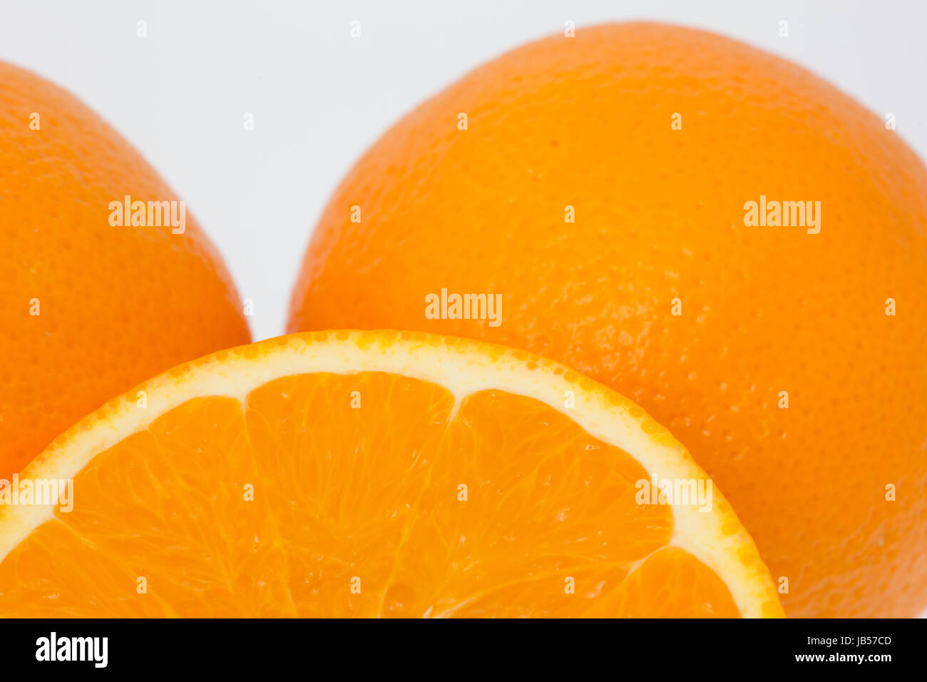Cross-section of an orange with whole oranges in the background Stock ...