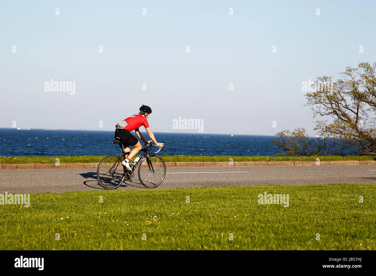 Lonely man riding his bicycle with the ocean in the background Stock ...