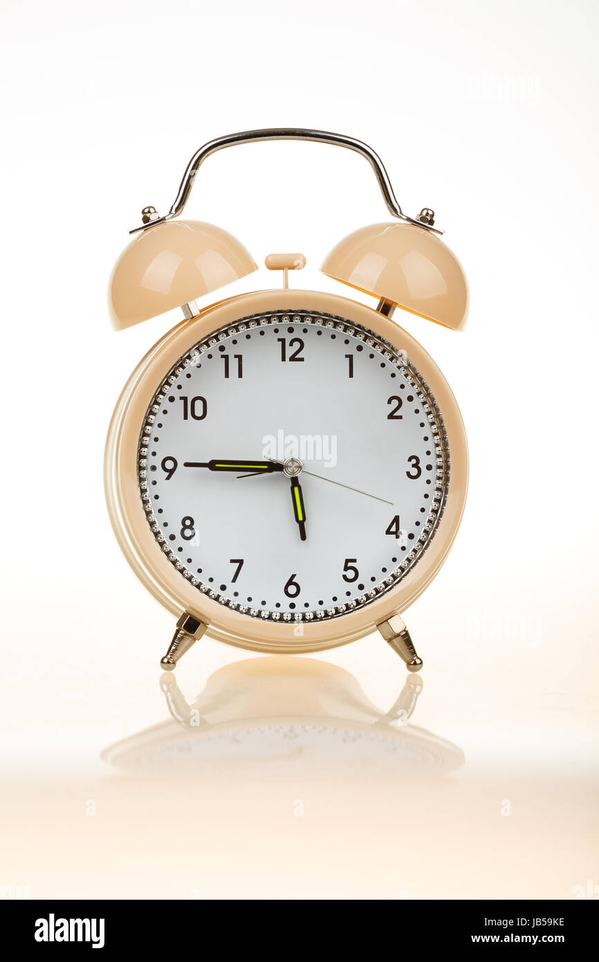classic alarm clock on white table with reflection Stock Photo - Alamy