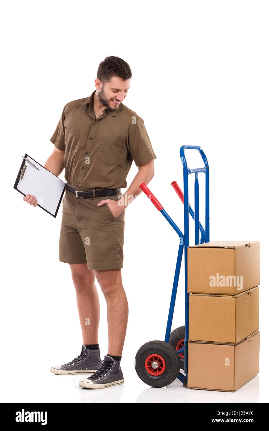 Delivery man pushing stack packages Cut Out Stock Images & Pictures - Alamy