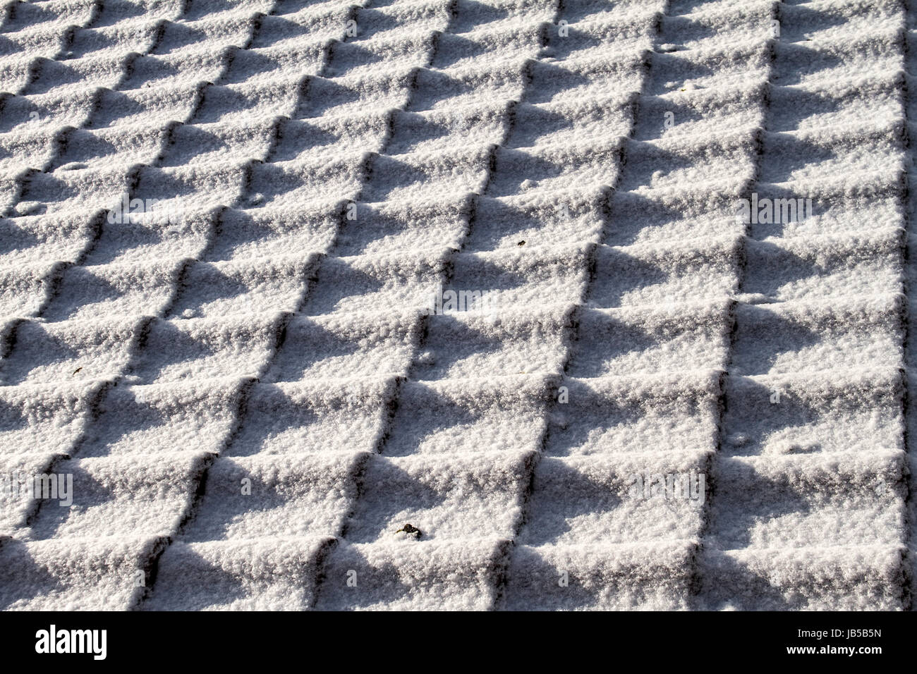 One snowy tiled roof background Stock Photo - Alamy