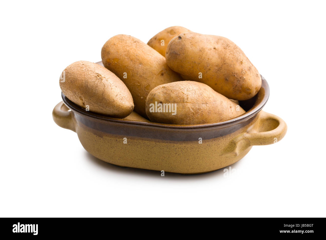 uncooked potatoes in ceramic pot on white background Stock Photo - Alamy