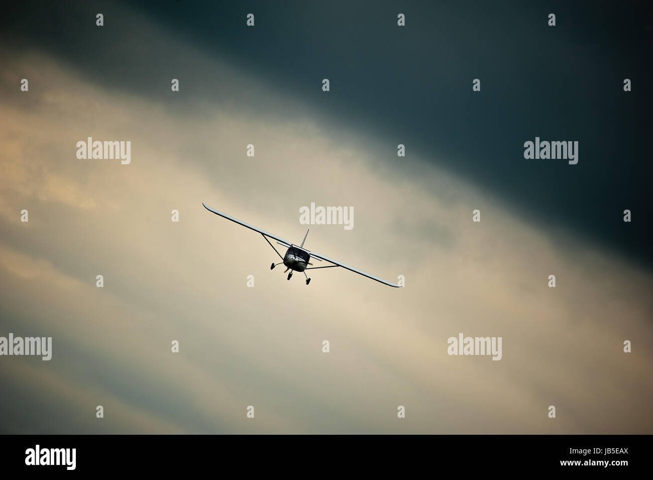 Small airplane in flight under a cloudy summer sky Stock Photo - Alamy