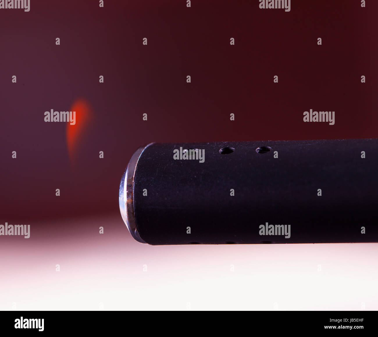 Black lighter with lit flame near a candle, close up Stock Photo - Alamy