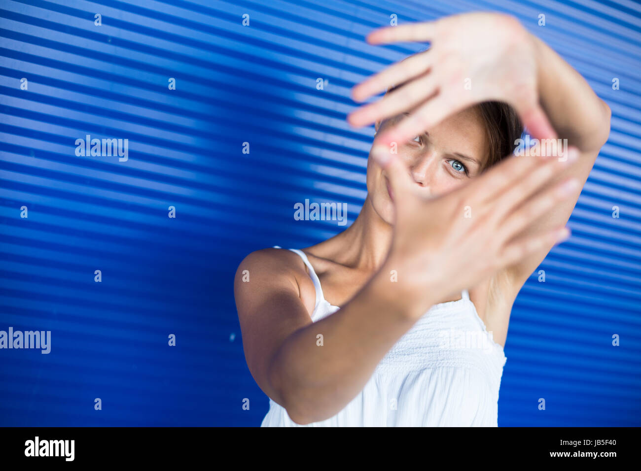 Pretty, young woman making a photo composing/shooting gesture with her ...