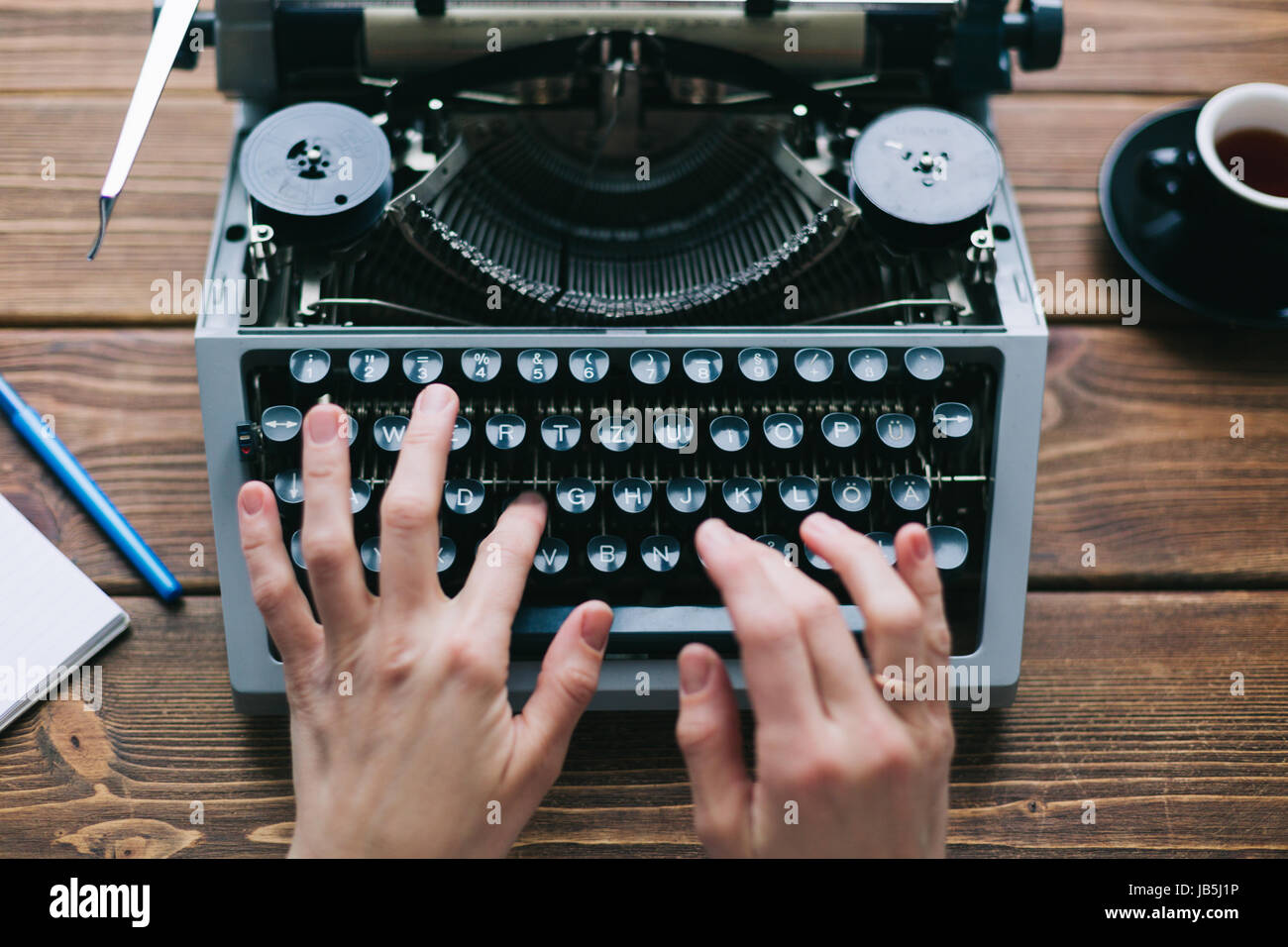 From above crop shot of person using typewriter on wooden table Stock ...