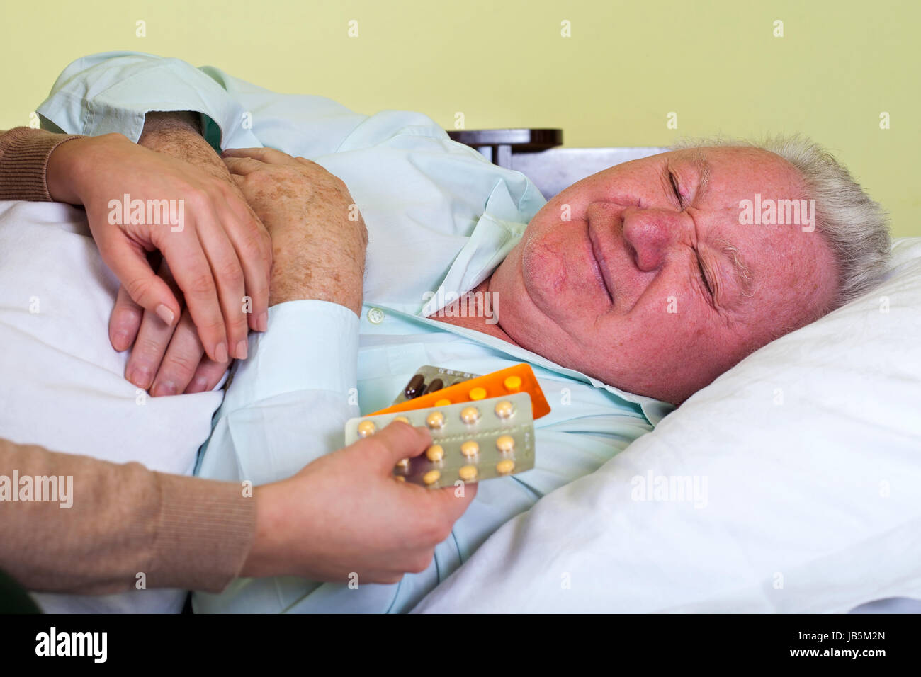 Picture of a sick elderly man with his carer holding medication Stock ...