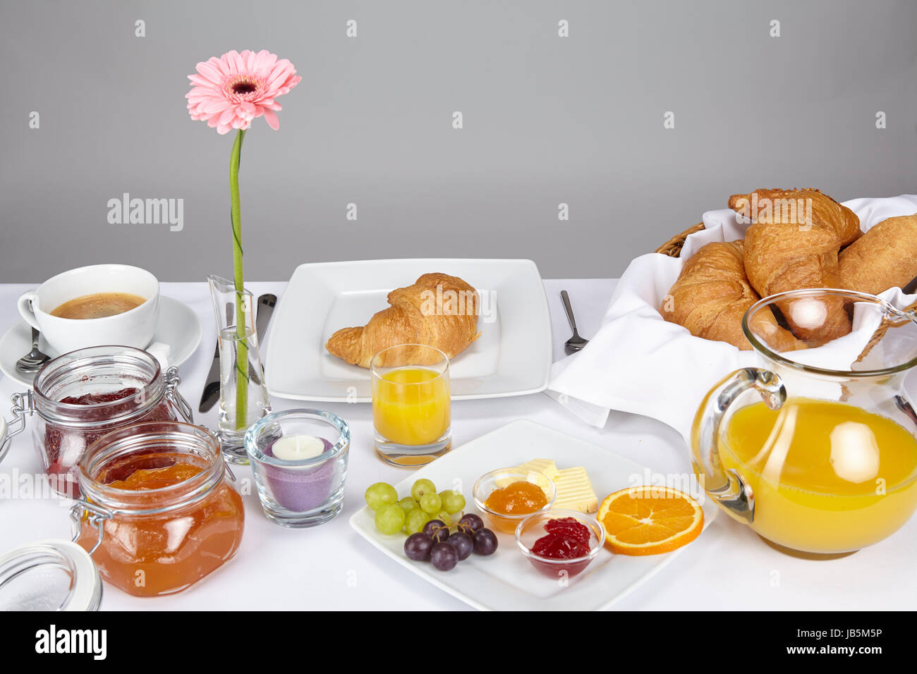 A well-laid breakfast table with a cup of coffee, a basket of ...