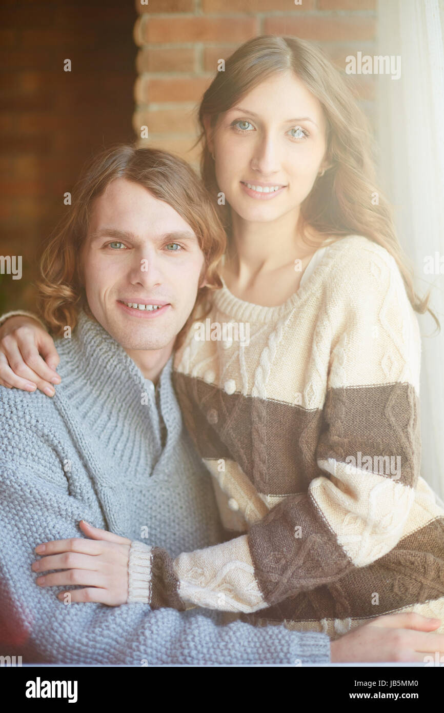 Portrait of amorous young dates embracing one another and looking at ...