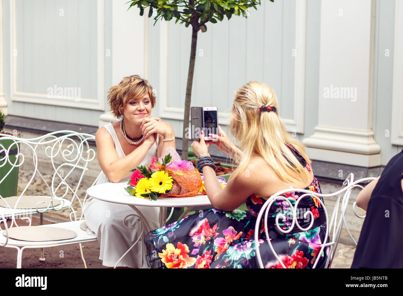 Two girls sitting outside cafe hi-res stock photography and images - Alamy