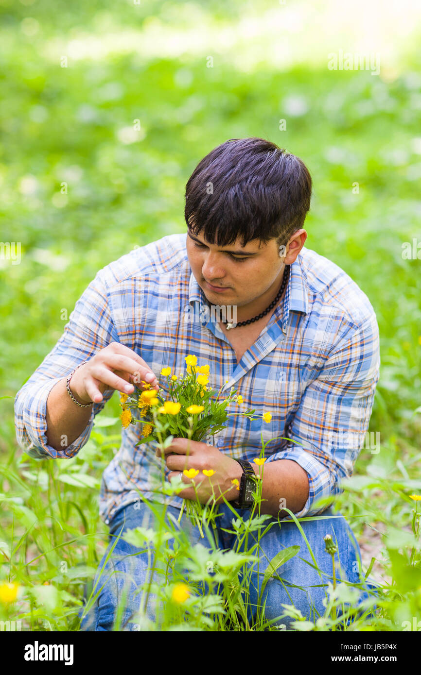 Young man picking up flowers for his woman Stock Photo - Alamy