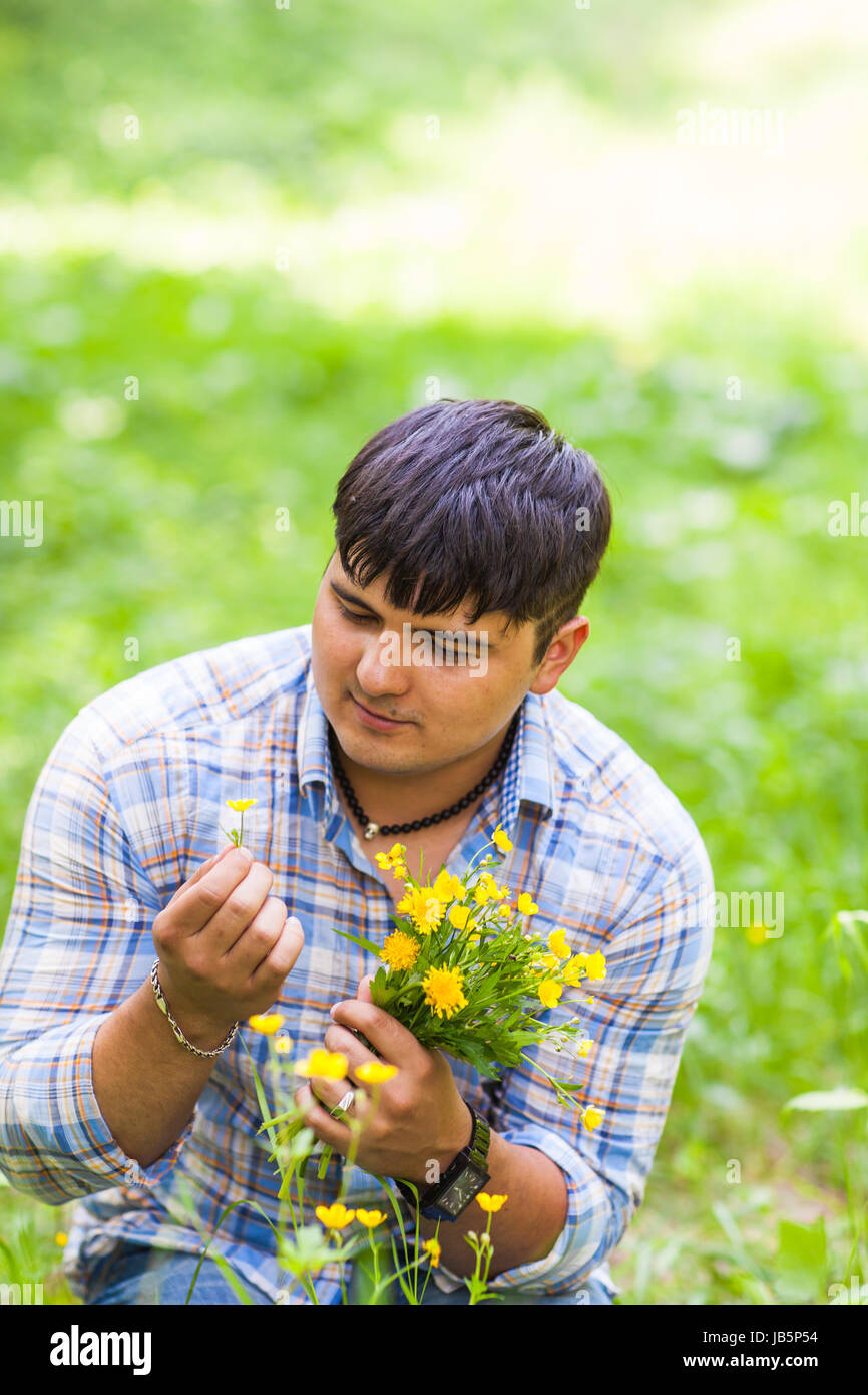 Young man picking up flowers for his woman Stock Photo - Alamy