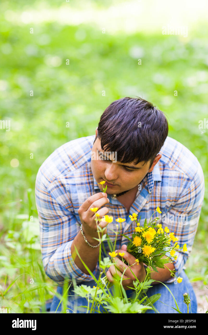 Young man picking up flowers for his woman Stock Photo - Alamy