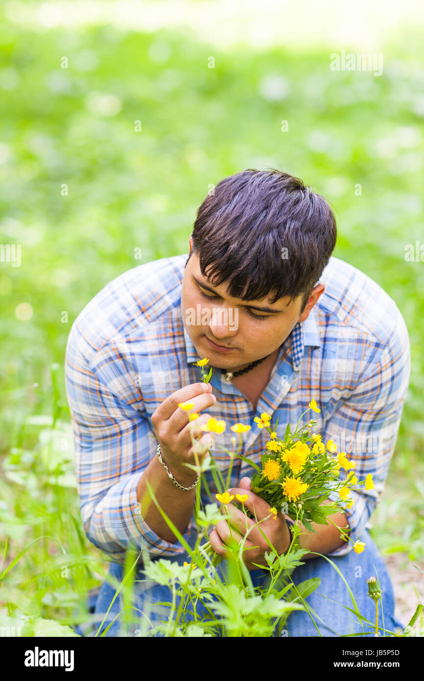 Young man picking up flowers for his woman Stock Photo - Alamy