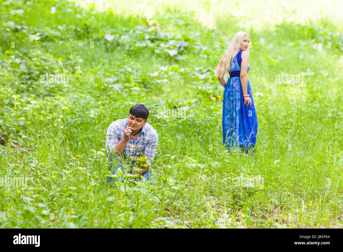 Young man picking up flowers for his woman Stock Photo - Alamy