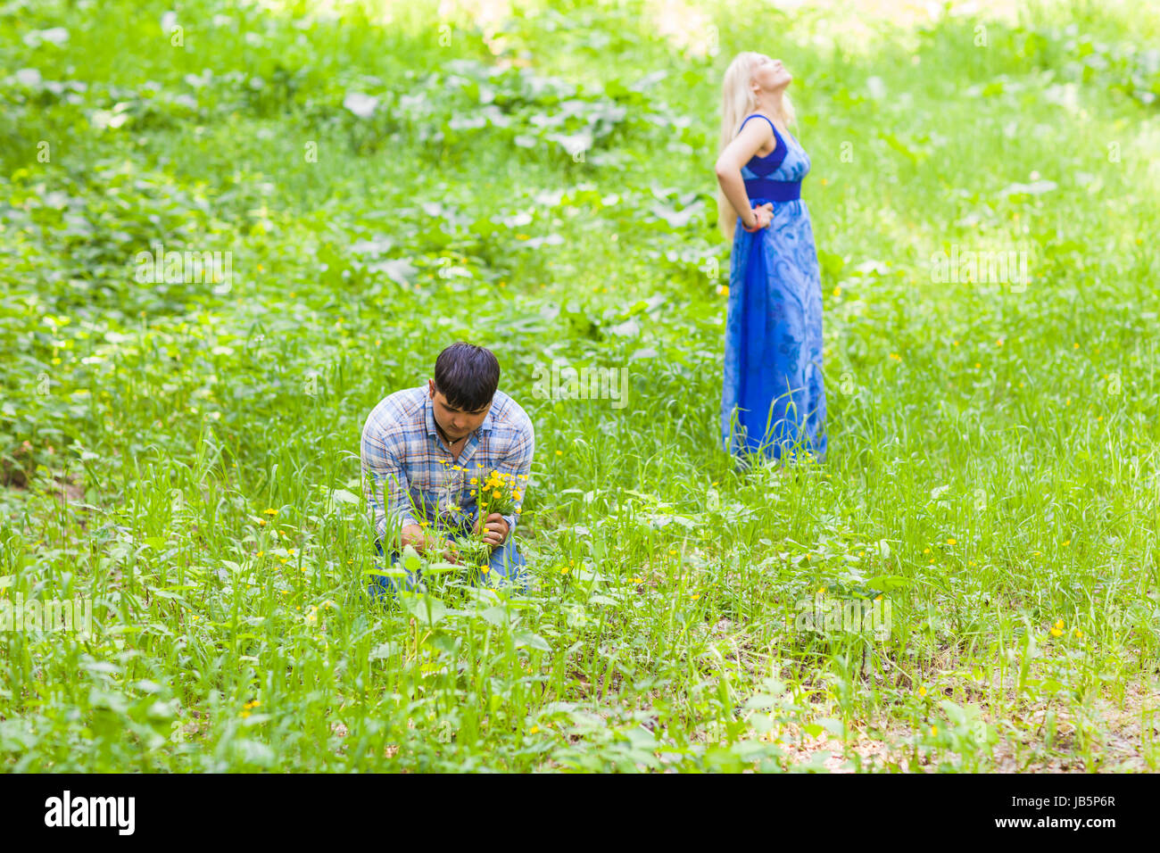 Young man picking up flowers for his woman Stock Photo - Alamy