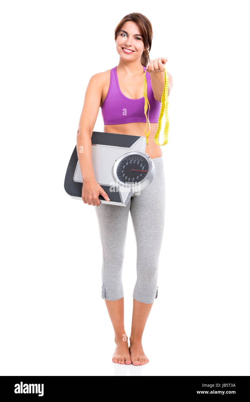 Beautiful athletic woman smilling and holding a scale and a measure ...